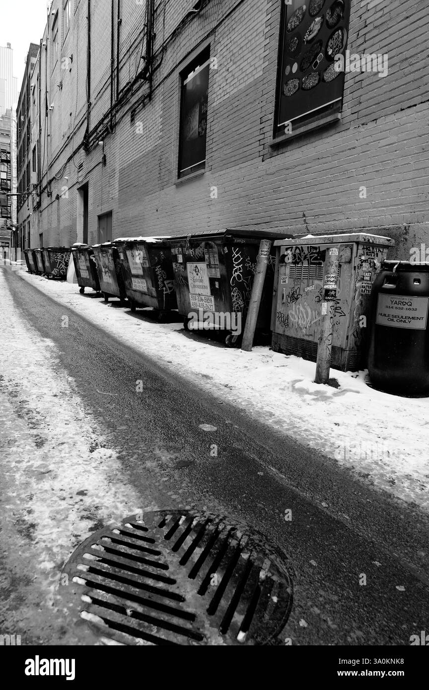 Downtown alleyway, manhole cover, graffiti-covered dumpsters and icy ...