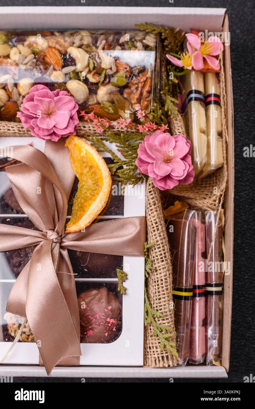 Gift box with a jar of nuts with honey, chocolate and craft candies ...
