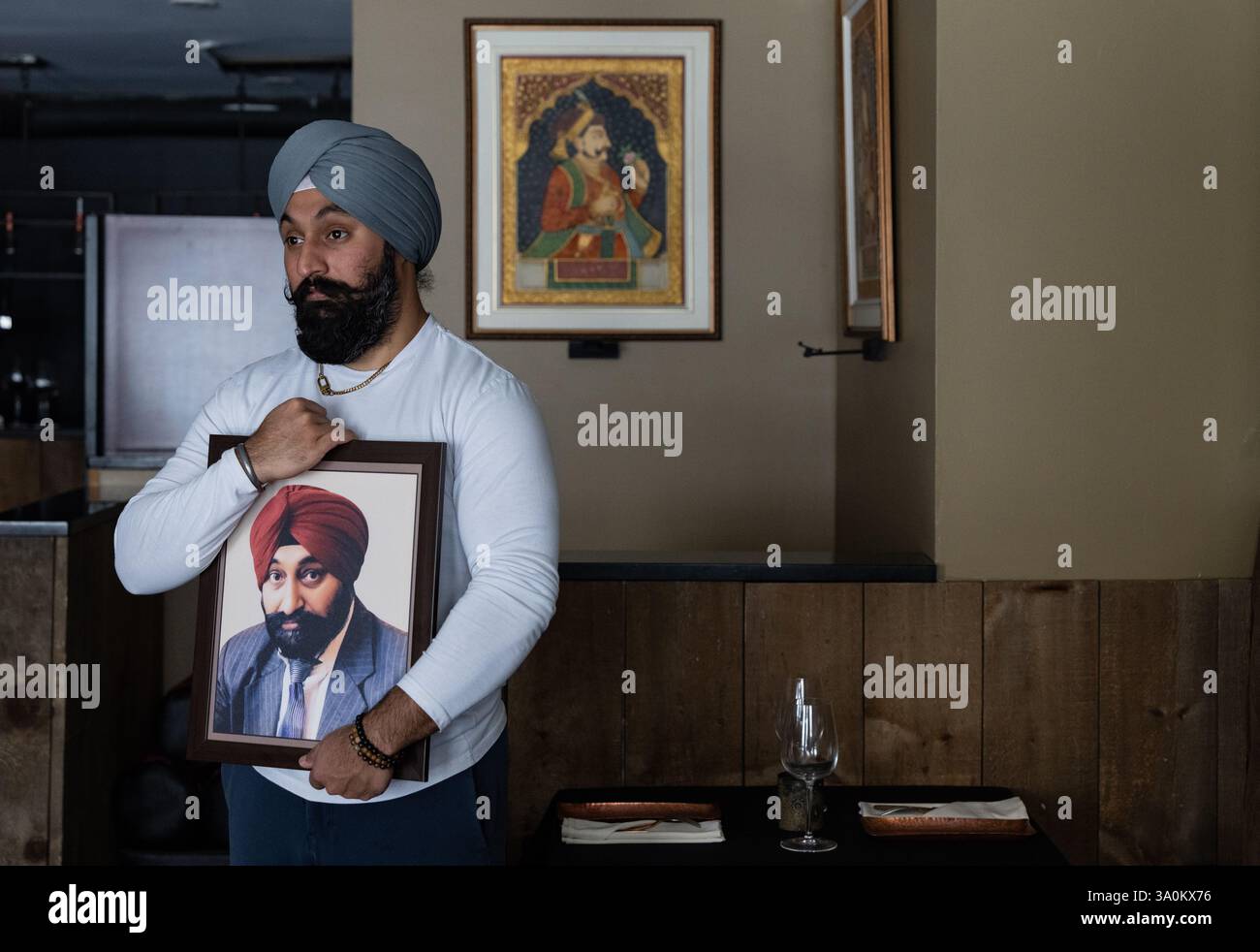 Simar Singh Anand, who calls himself a steward of legacy, holds a photo ...