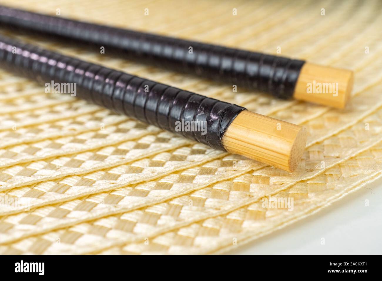 Detailed view of traditional bamboo chopsticks on woven mat surface ...