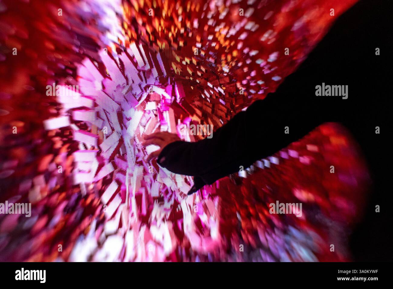 Barcelona, Spain. 4 March, 2025: A hostess moves some graphics with her ...