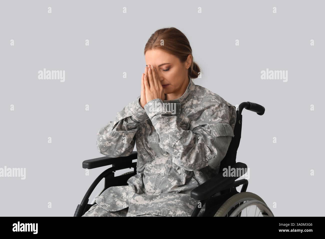Sad female soldier in wheelchair on light background Stock Photo - Alamy