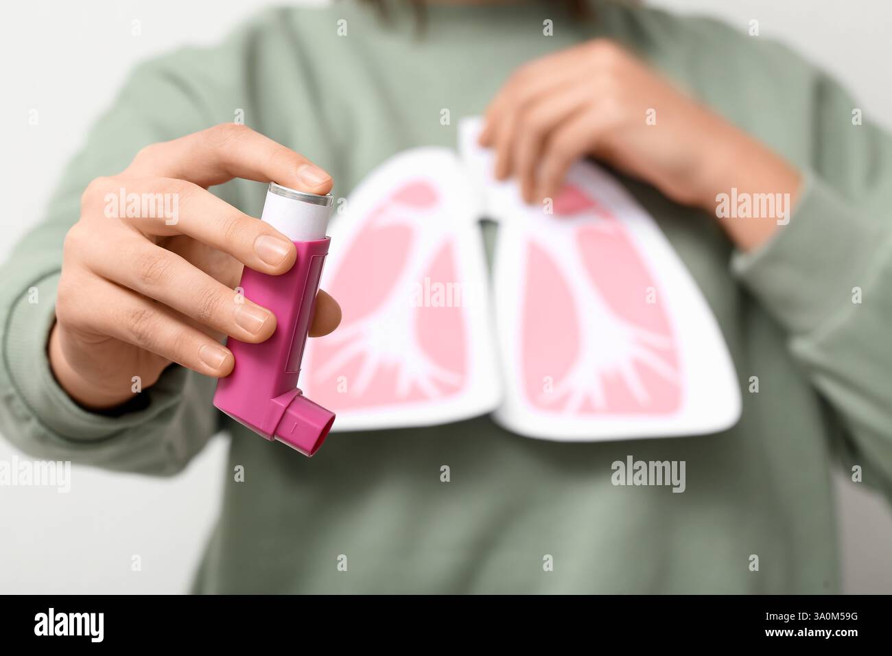 Young woman with paper lungs and asthma inhaler on white background ...