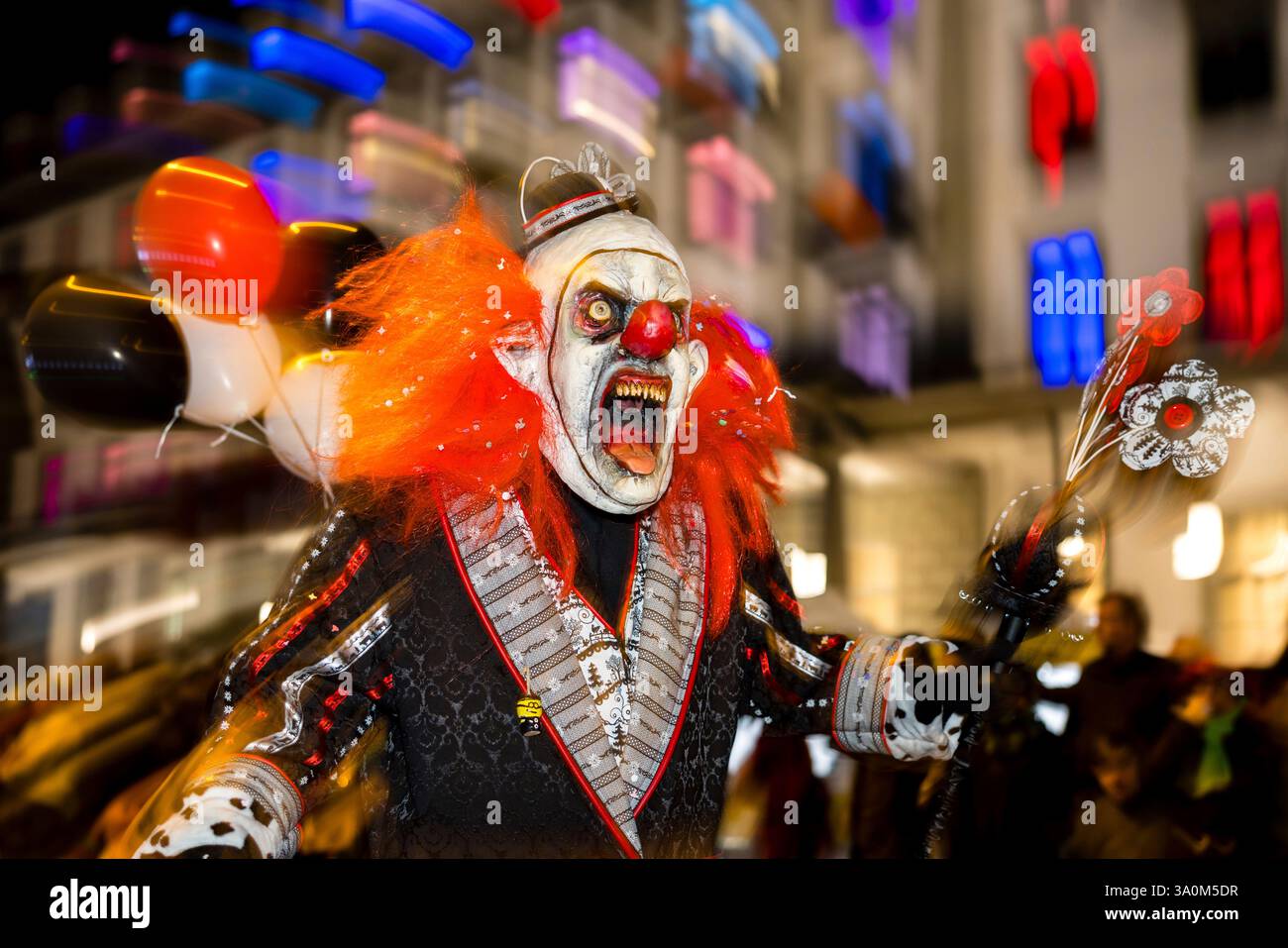 A participant dressed as a clown parades through the streets during the ...