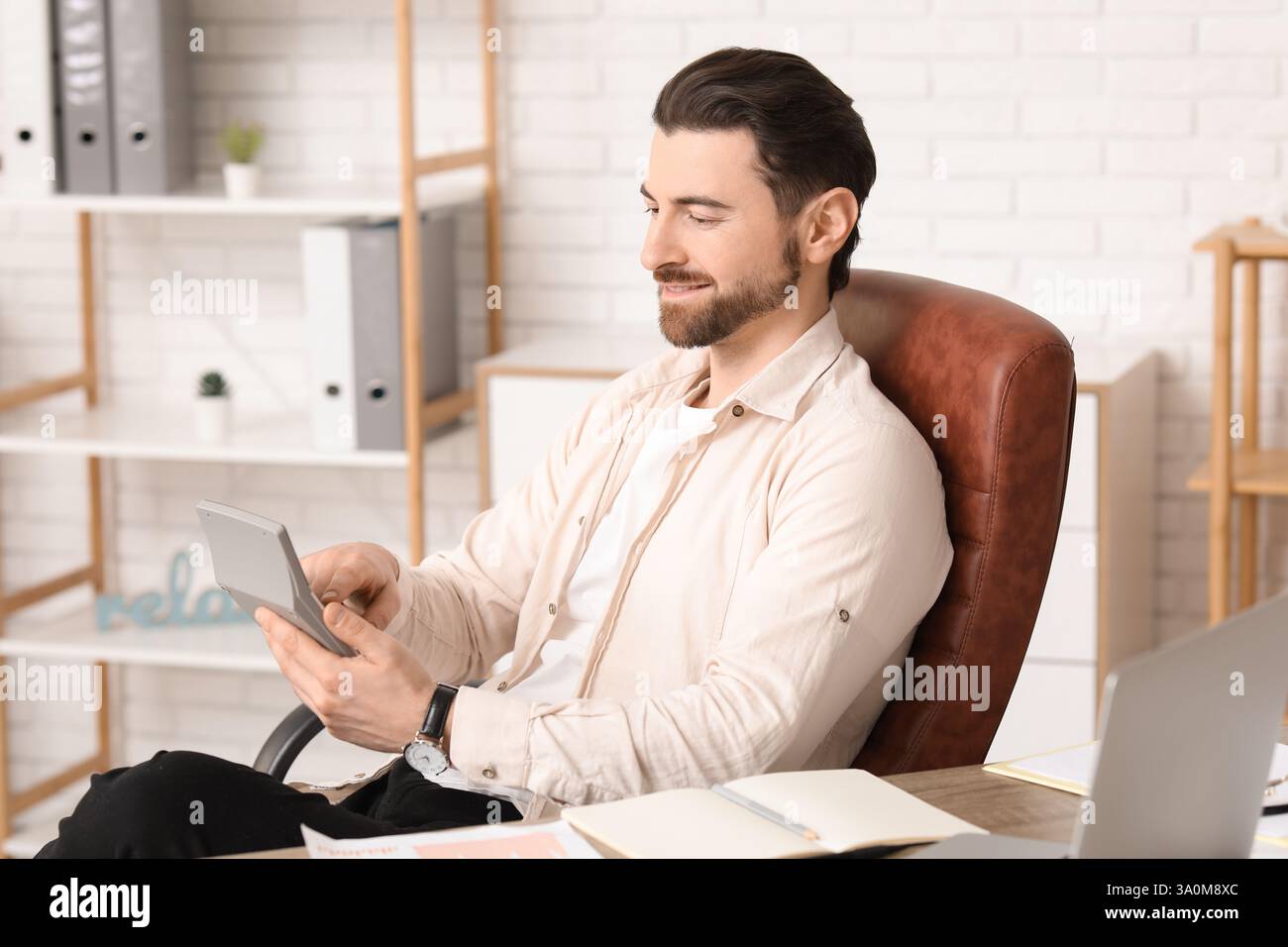 Young man doing calculations in office Stock Photo - Alamy