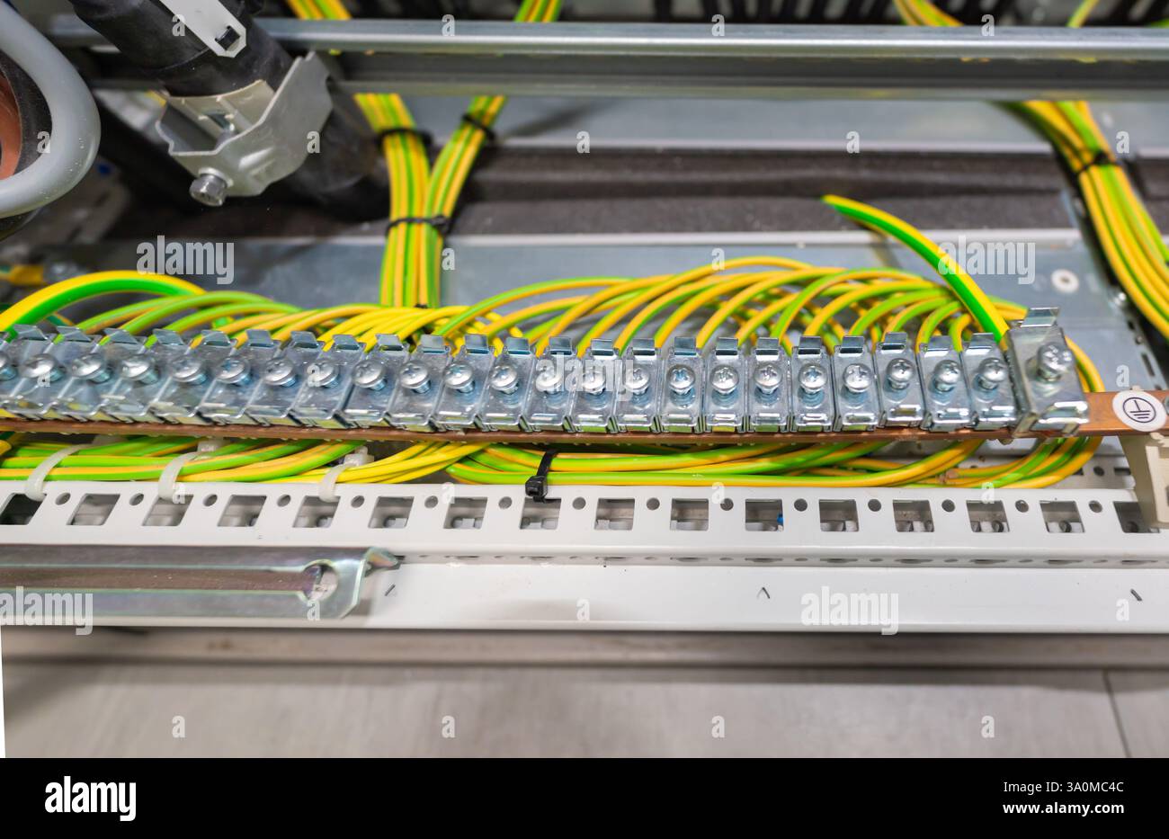 Grounding busbar with connected yellow-green wires inside an industrial ...