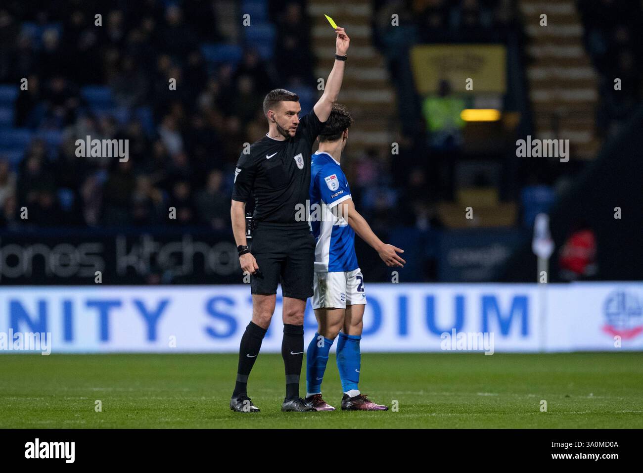 Referee Thomas Kirk shows a yellow card to Aaron Morley #16 of Bolton ...