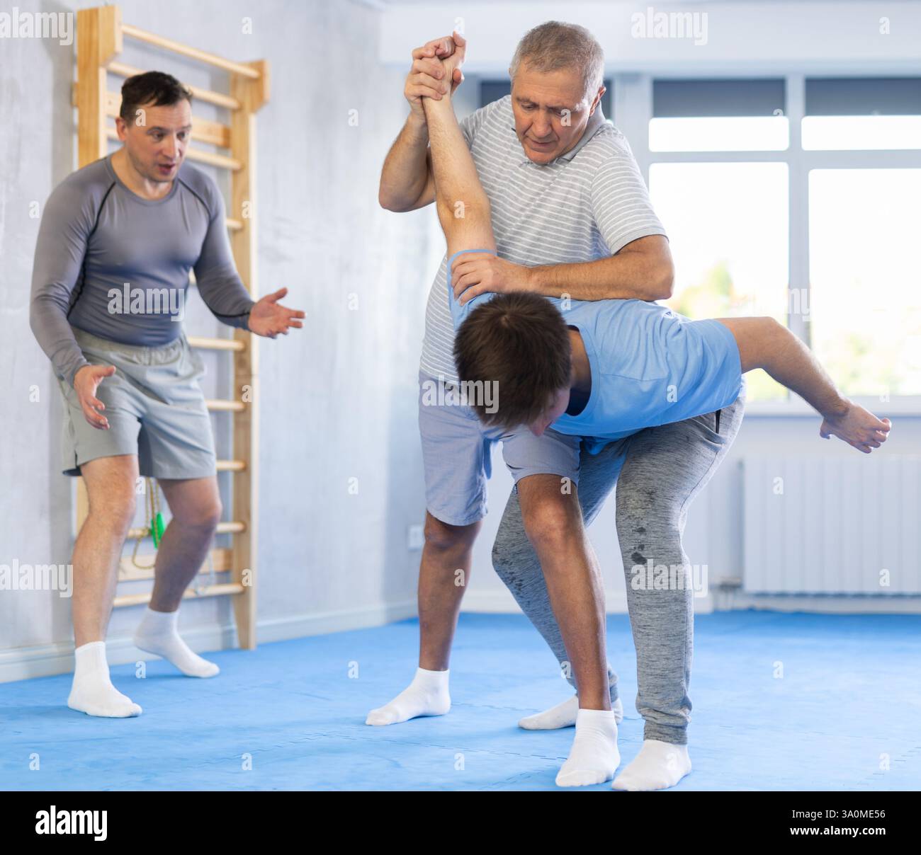 Mature man throws guy to the mat - two men of different ages in judo ...