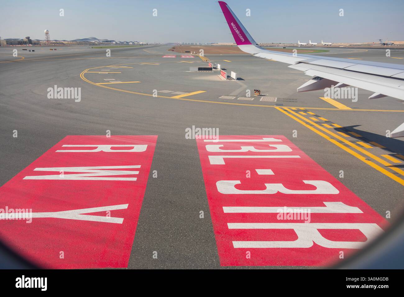 View from airplane window of runway markings and aircraft wing at Abu Dhabi airport Stock Photo ...