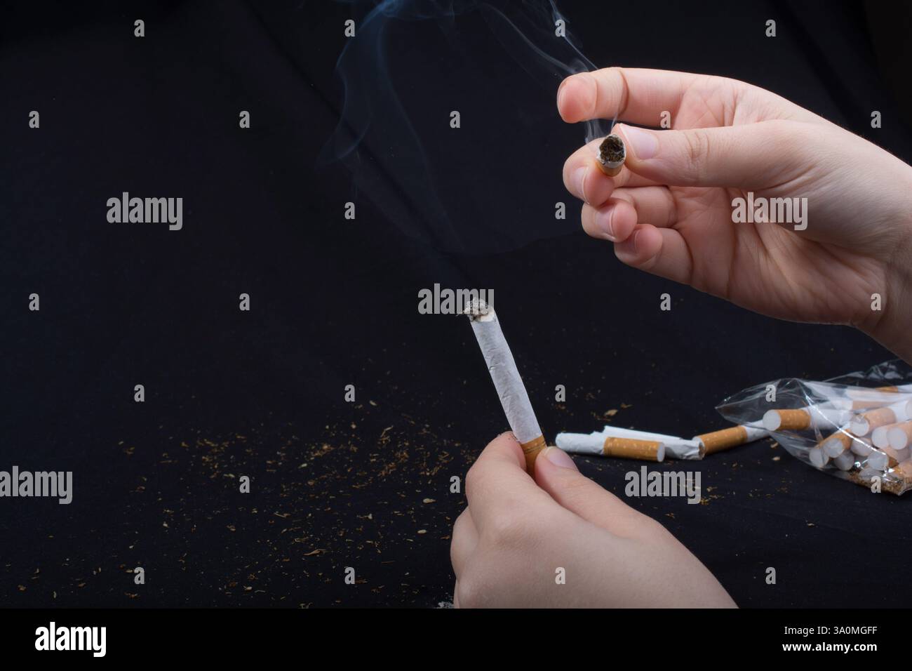 Hand is holding smoking cigarette with smoke around Stock Photo - Alamy