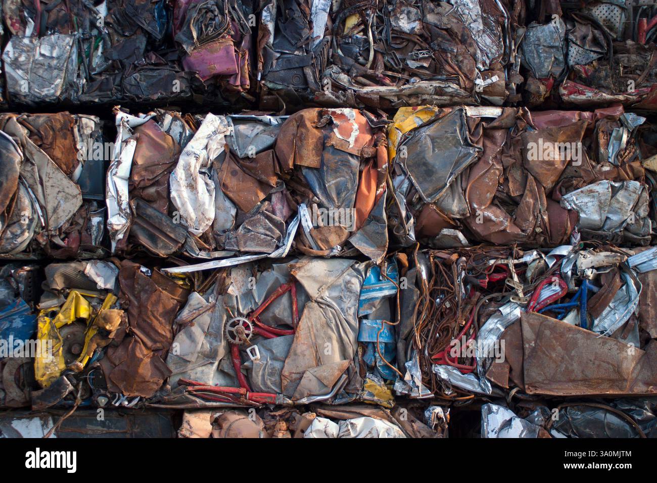 old bicycle wheel on blue background in crushed and baled scrap metal ...