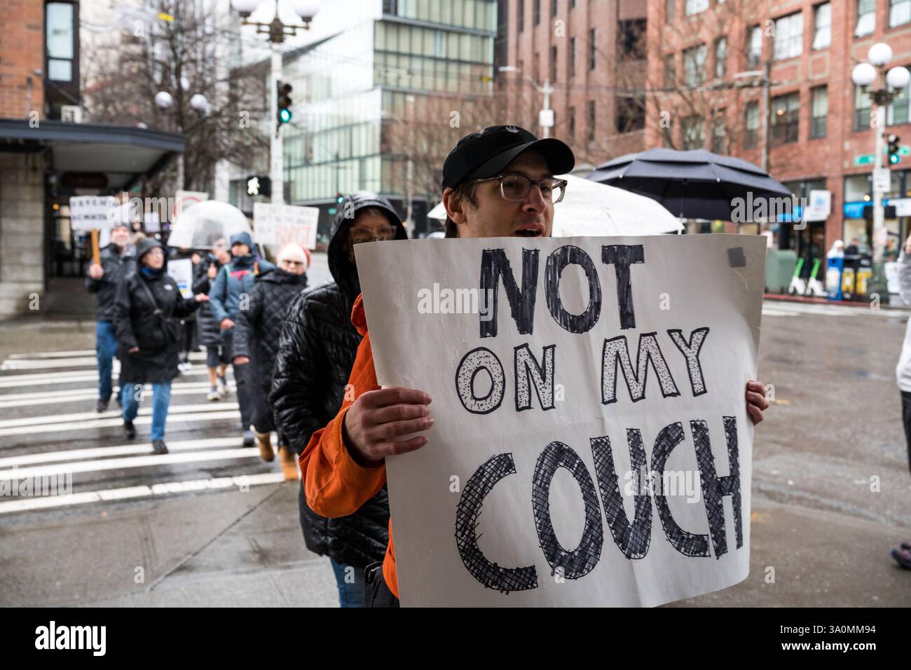 Seattle, USA. 4th Mar 2025. Activists march through Pike Place Market ...