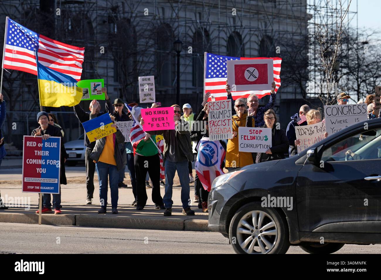 Protestors against the Trump administration hold signs for passing ...