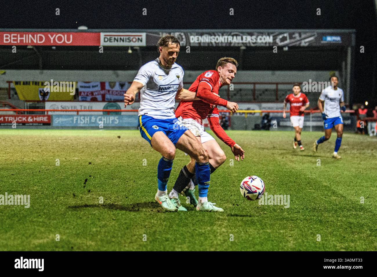 Joe Lewis of AFC Wimbledon tackles Morecambe FC's Ged Garner during the ...