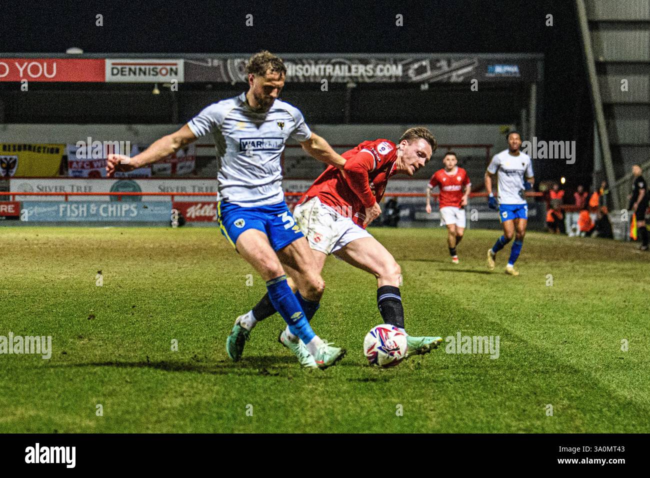 Joe Lewis of AFC Wimbledon tackles Morecambe FC's Ged Garner during the ...