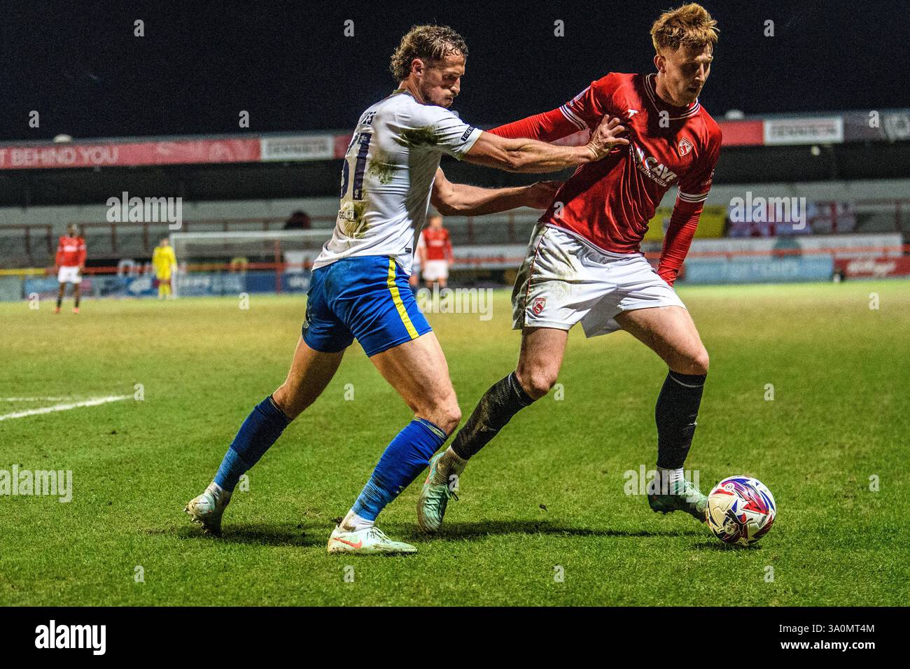 Joe Lewis of AFC Wimbledon tackles Morecambe FC's Ged Garner during the ...