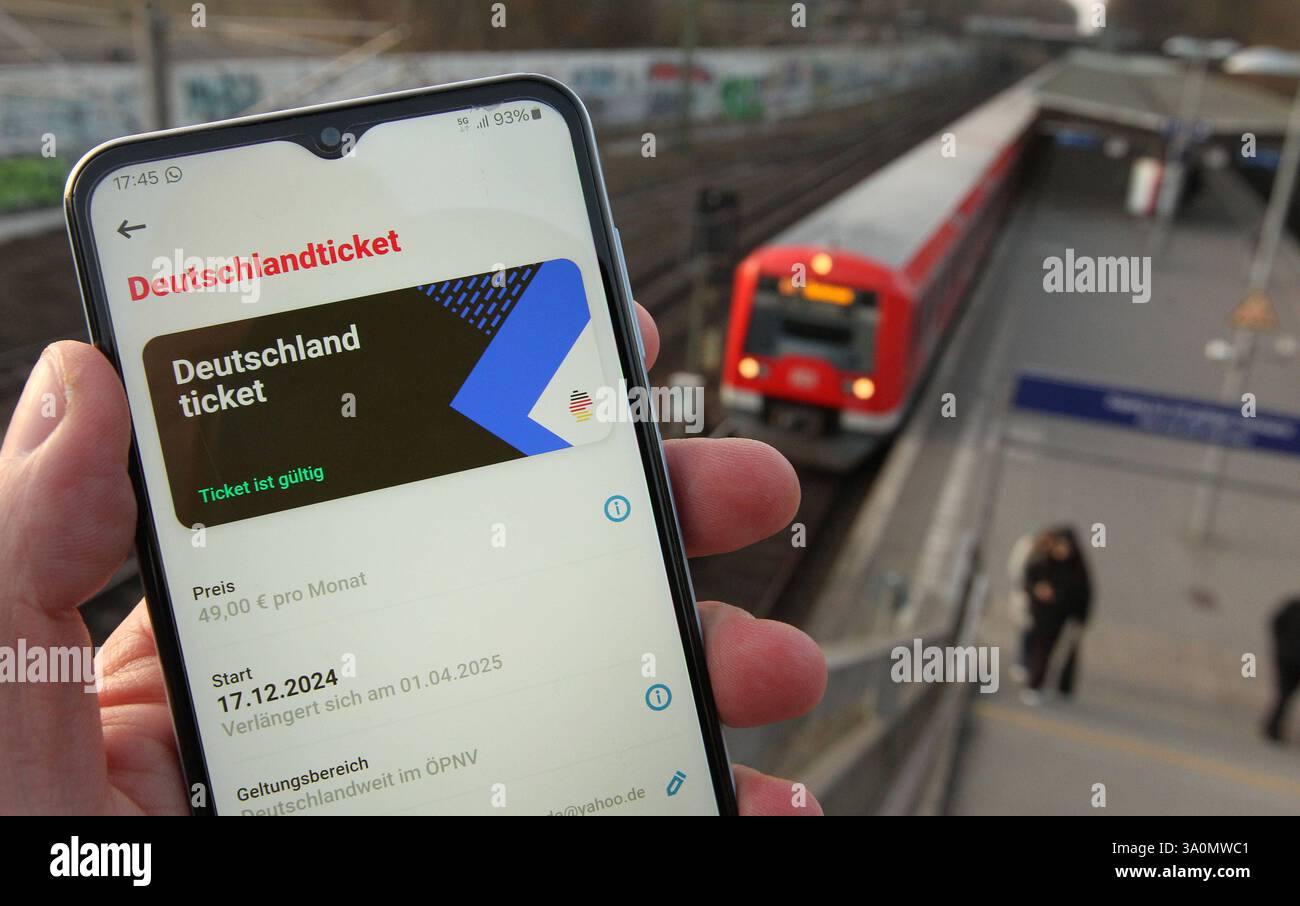 Ein Mann hält auf dem S-Bahnhof Rübenkamp sein Smartphone in der Hand ...