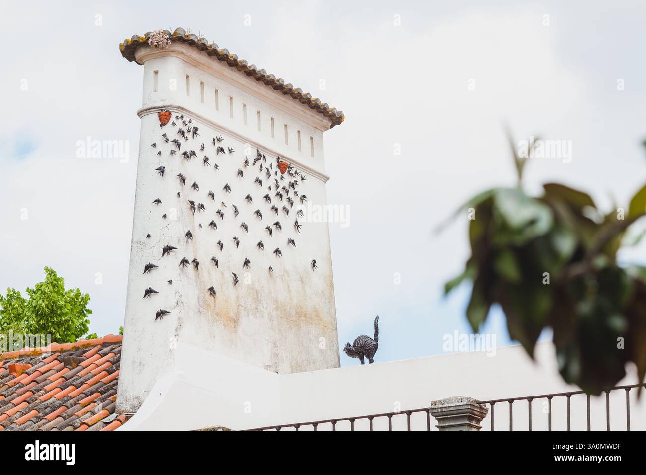 a chimney with clay figurines of a cat and swallows Stock Photo - Alamy