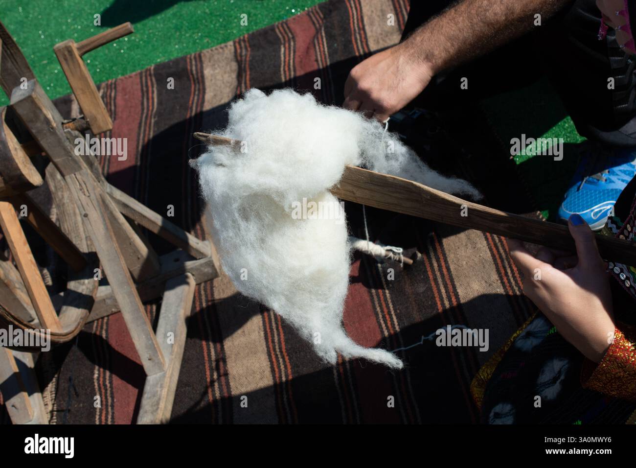 Spinner creates a thread of white wool. Creating yarn threads Stock ...