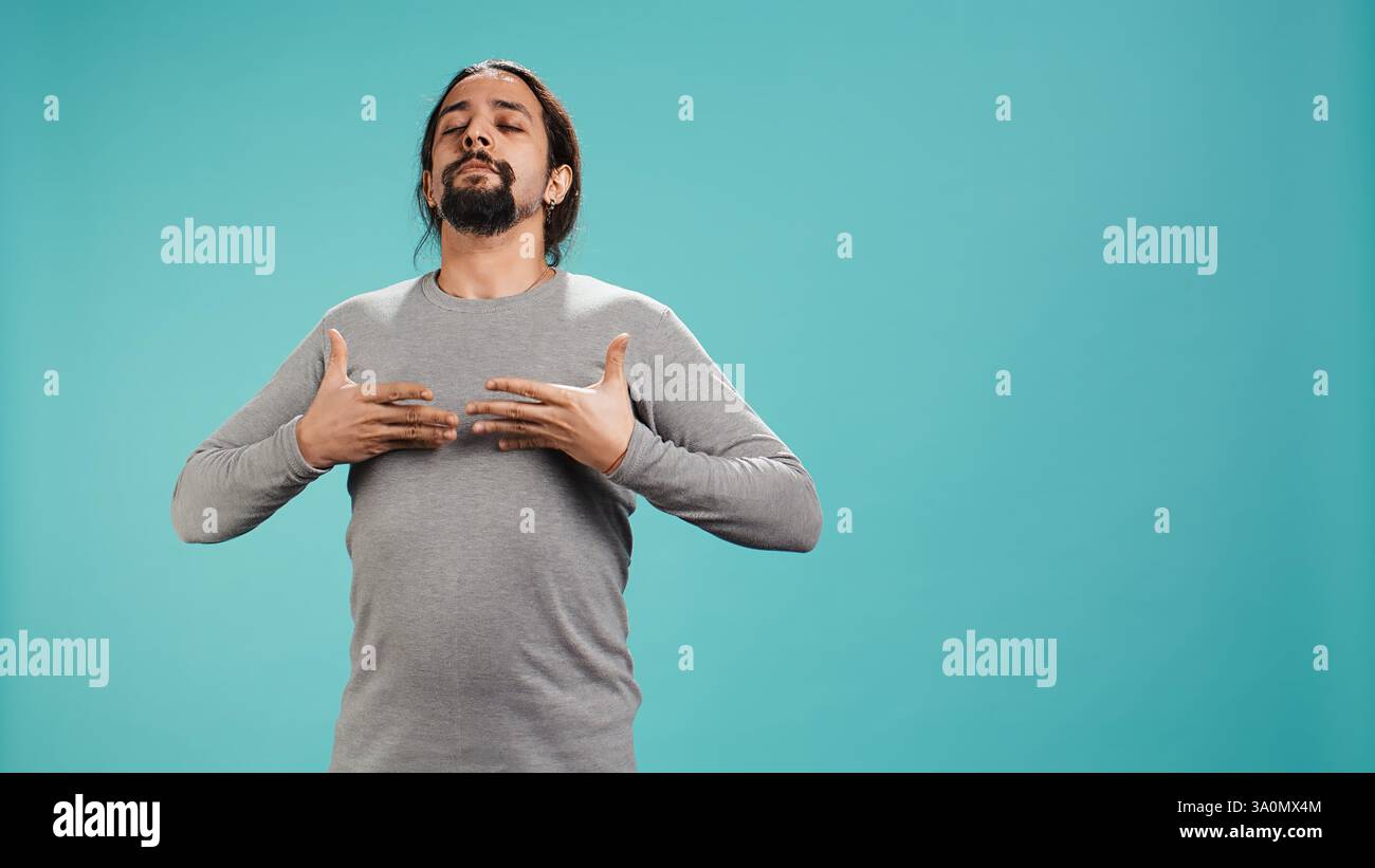 Portrait of man inhaling and exhaling to relax and gain positive energy ...