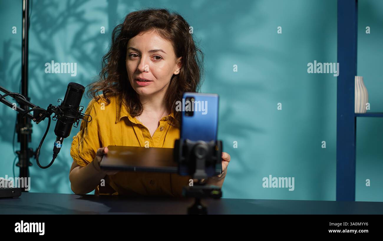 Internet show host using smartphone on phone holder, filming content ...