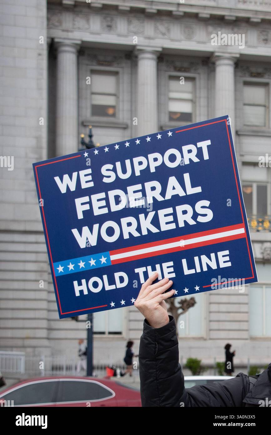 San Francisco, USA. 4th Mar 2025. A protester holds a sign reading, "We ...