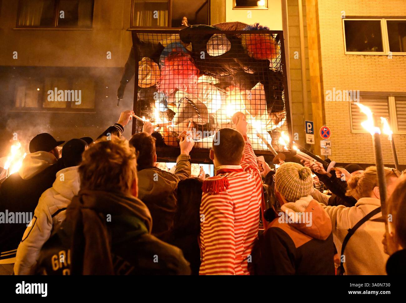 Cologne, Germany. 05th Mar, 2025. Carnival revelers set fire to their ...