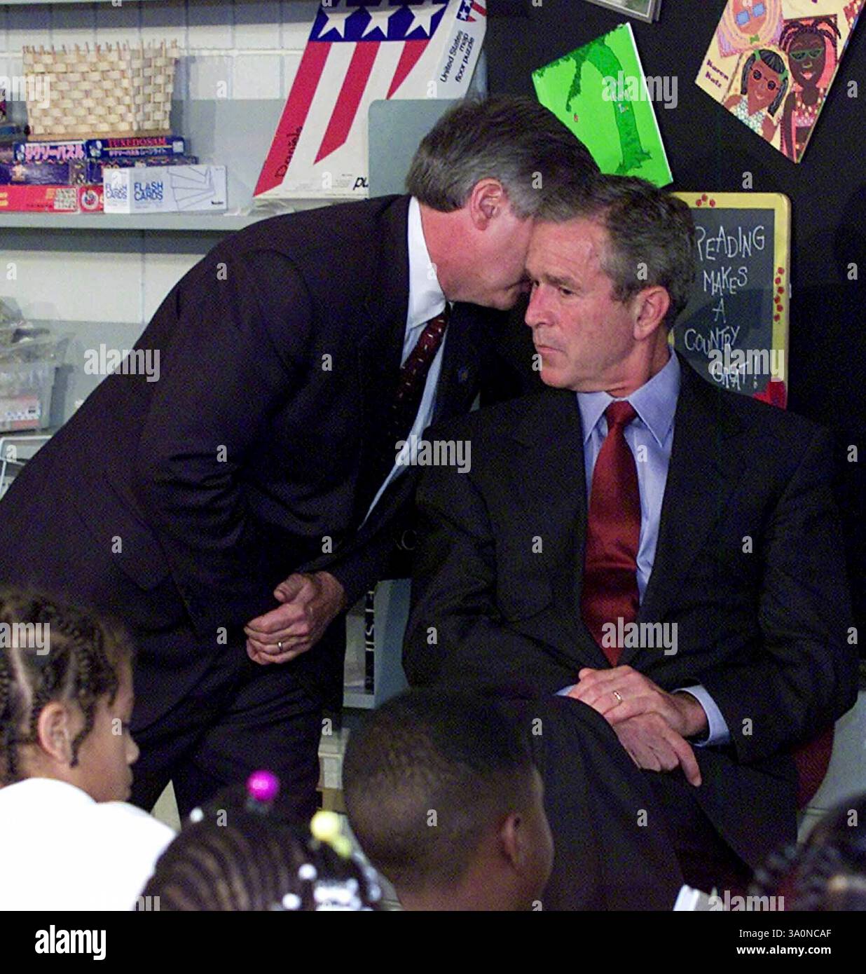 Chief of Staff Andy Card whispers into the ear of President George W ...