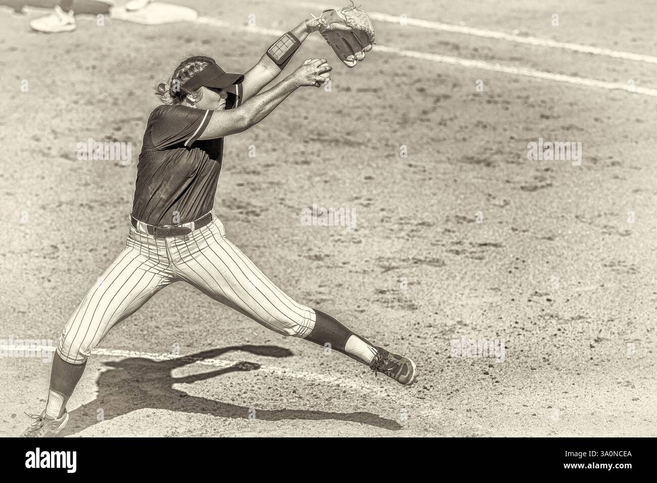 A Fast Pitch Softball Pitcher Is In Full Wind Up Pitching The Ball To ...