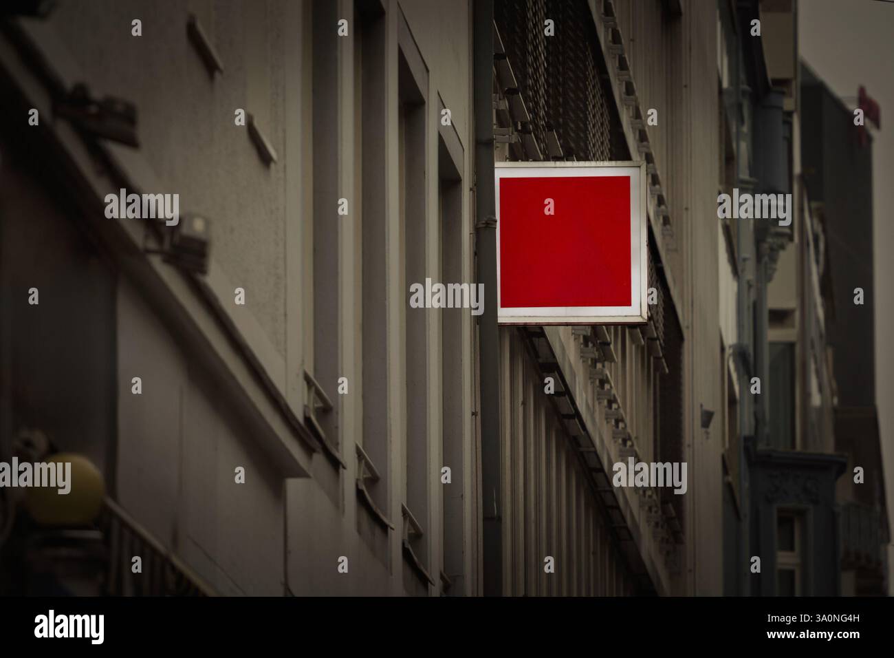 An empty red square sign affixed to the facade of an office building in ...