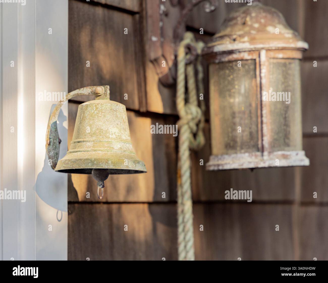 an old brass bell and small latern mounted next to a door Stock Photo ...