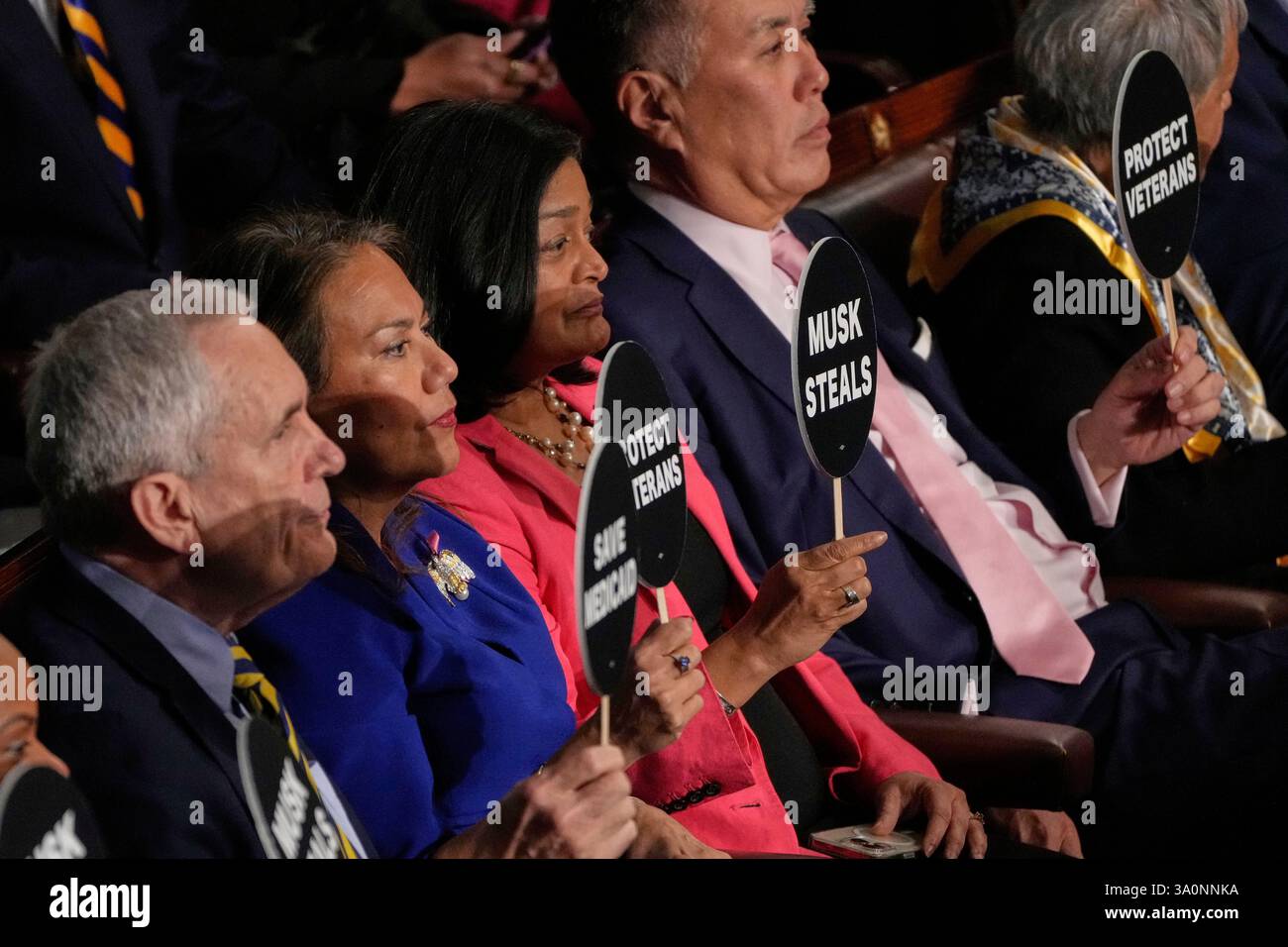 Democrats hold signs as President Donald Trump addresses a joint ...