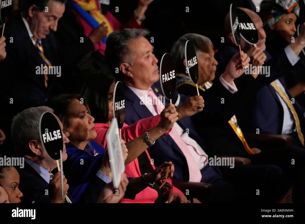 Democrats hold signs as President Donald Trump addresses a joint ...