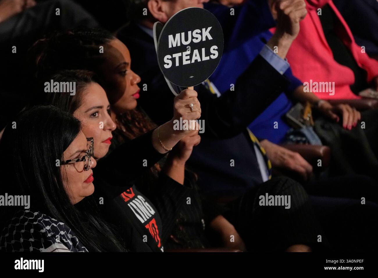 Democrats hold signs as President Donald Trump addresses a joint ...
