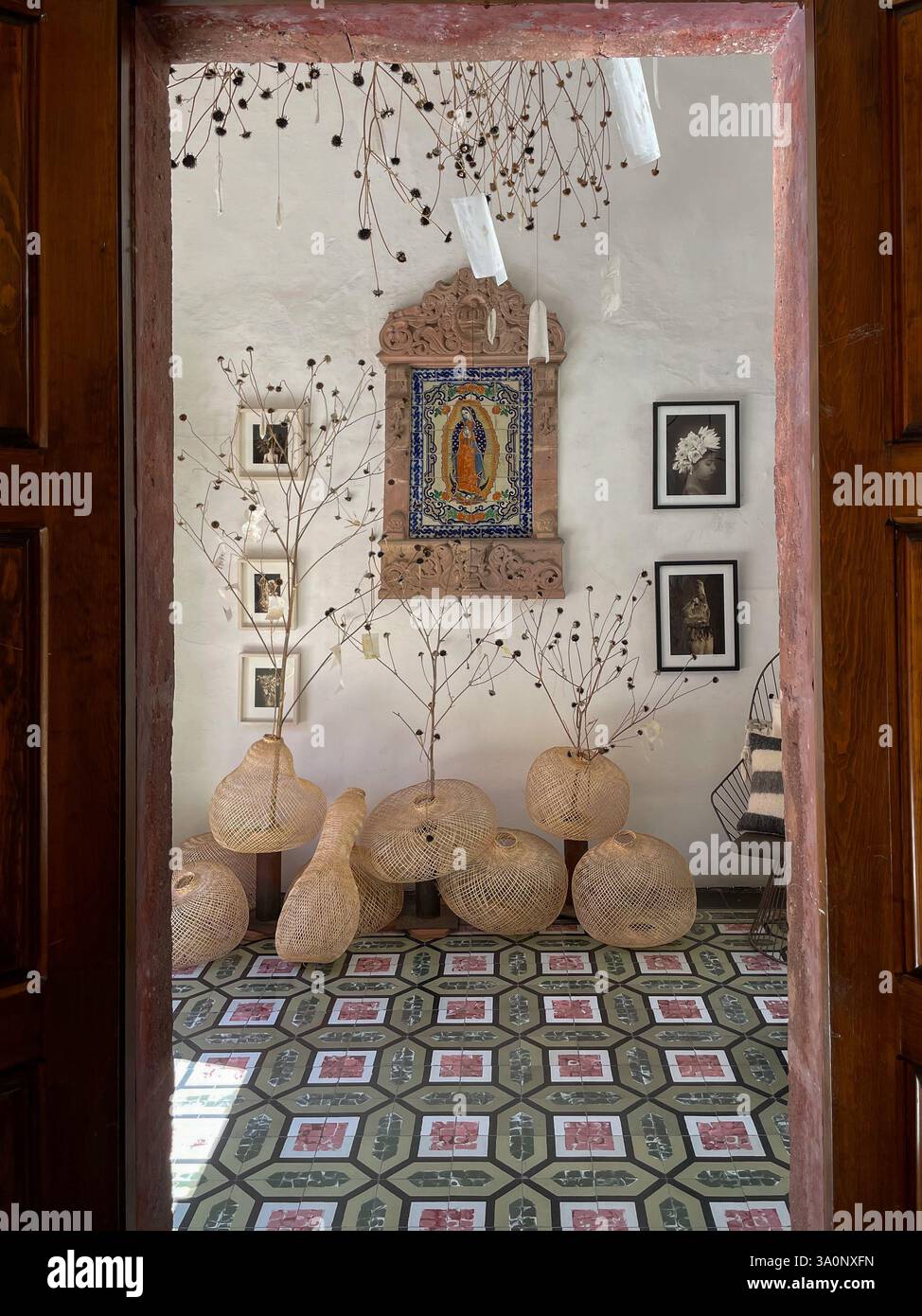 Old mexican house entrance with a virgin on a white wall and artisanal ...