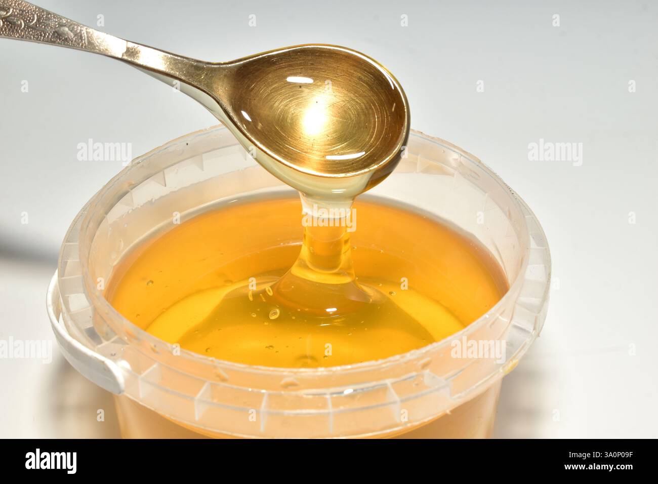 Thick, transparent, yellow honey flows in a continuous stream from the ...
