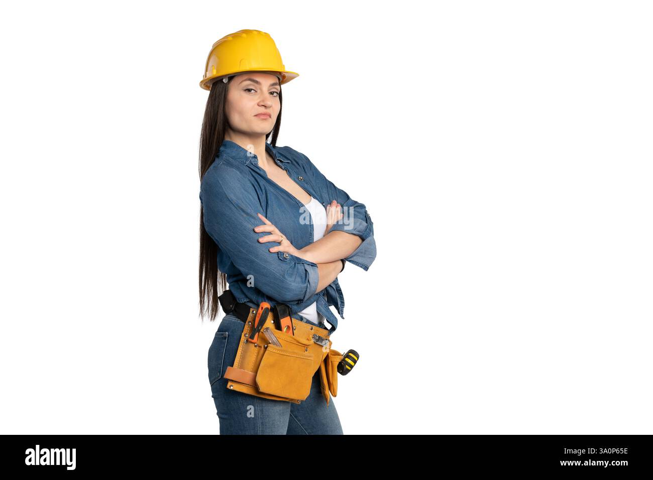 A determined female construction worker wearing a yellow hard hat and ...