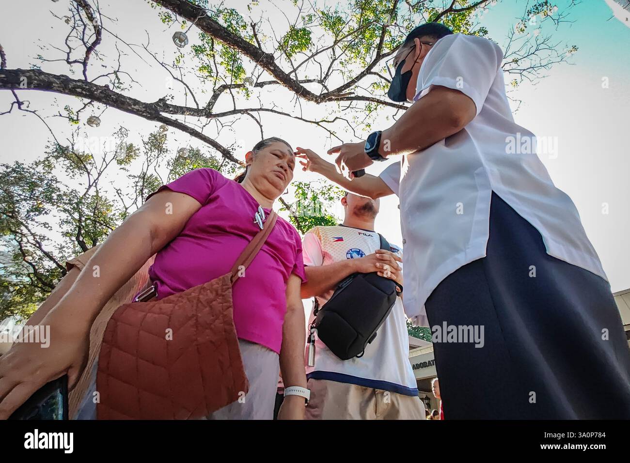 Catholic faithful line up to receive ash marks in the shape of a cross ...