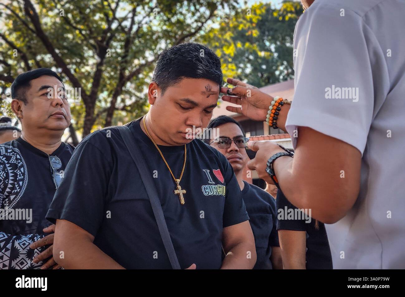 Catholic faithful line up to receive ash marks in the shape of a cross ...