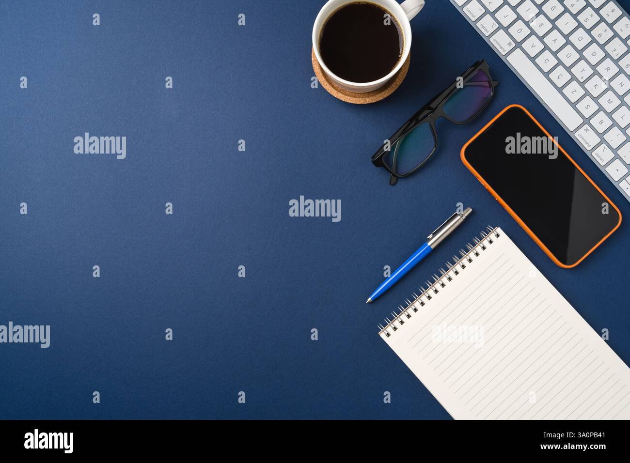 Blank touchscreen smartphone and keyboard on dark blue desk Stock Photo ...