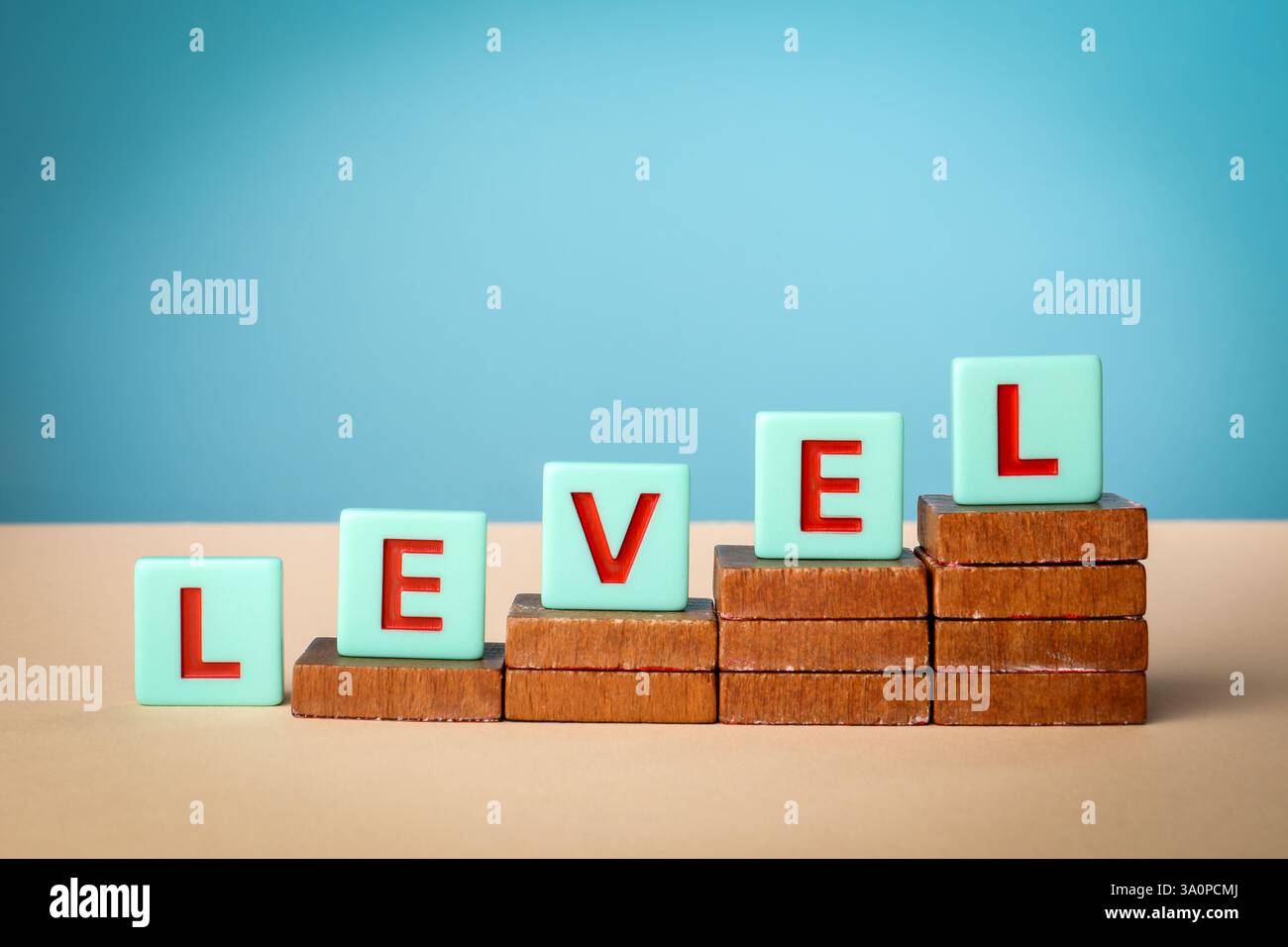 Level. Alphabet blocks on wooden blocks. Light background Stock Photo ...