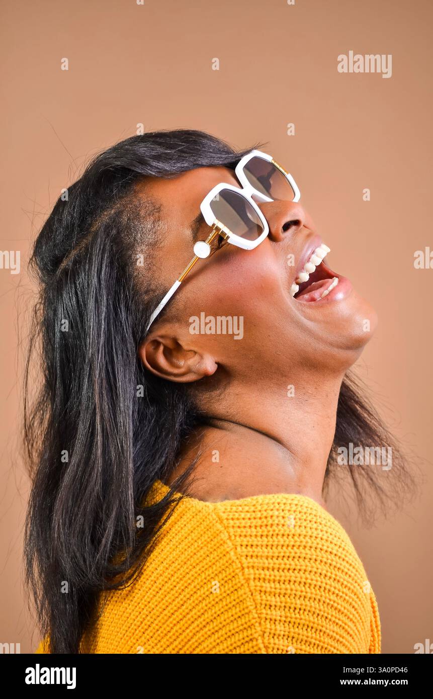 Studio portrait of a cheerful black woman wearing stylish sunglasses ...