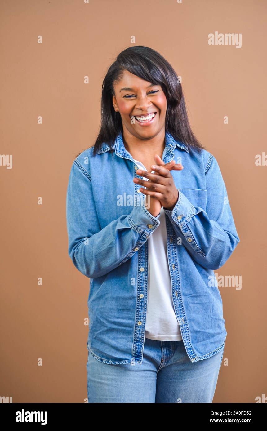 Studio portrait of a cheerful african american woman clapping her hands ...