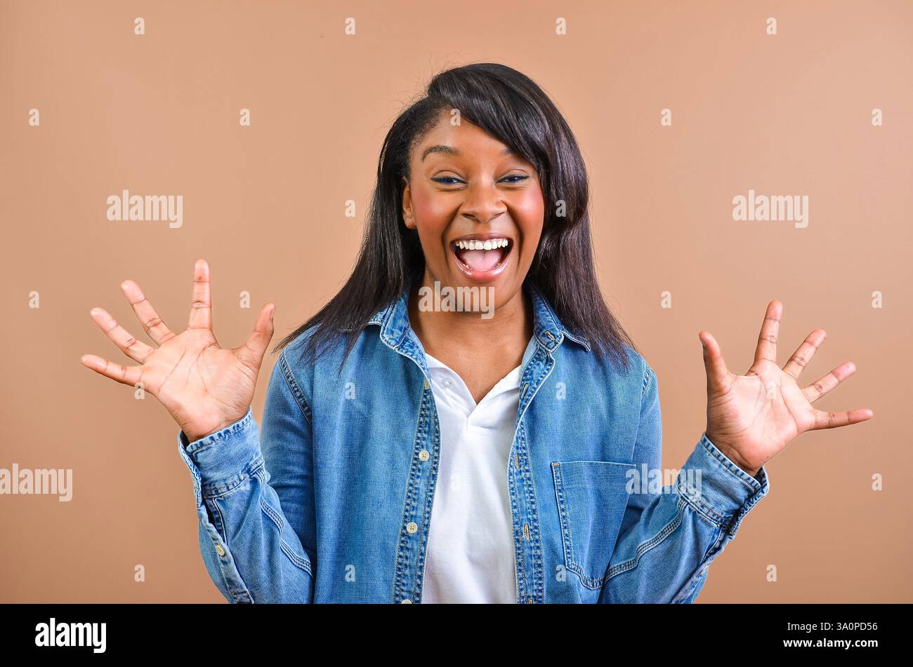 Studio portrait of a cheerful young woman expressing joy and excitement ...