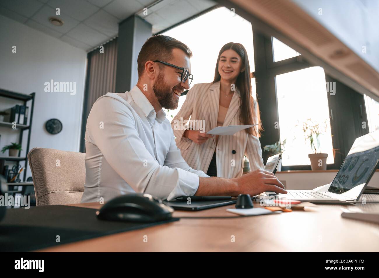 Side view. Paper work. Two employees are together in the modern office ...