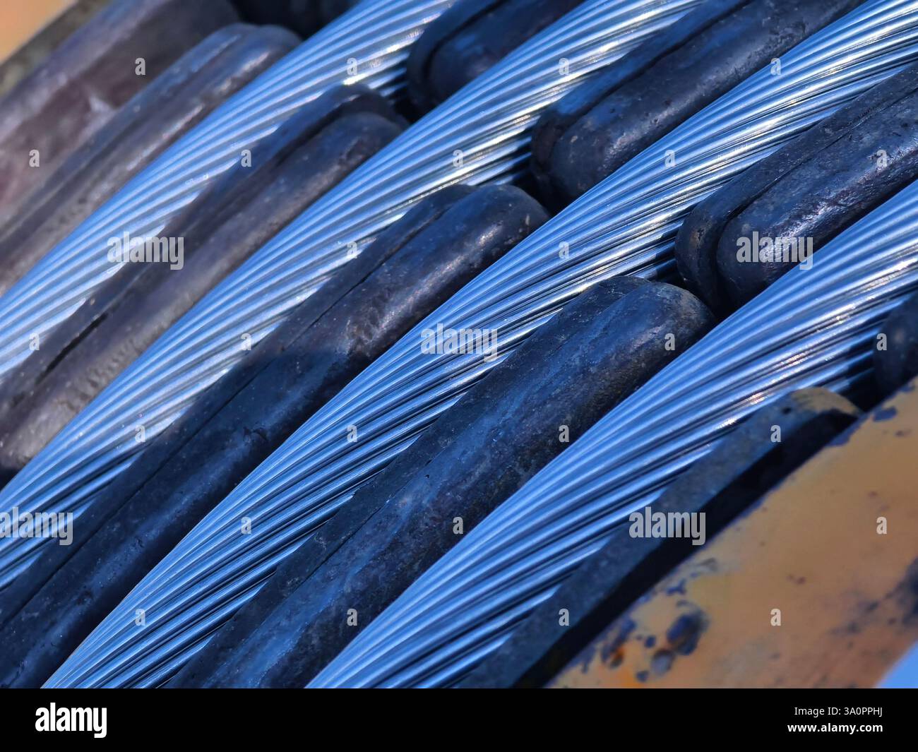 A large wooden spool of high-voltage electric wires is located on the ...