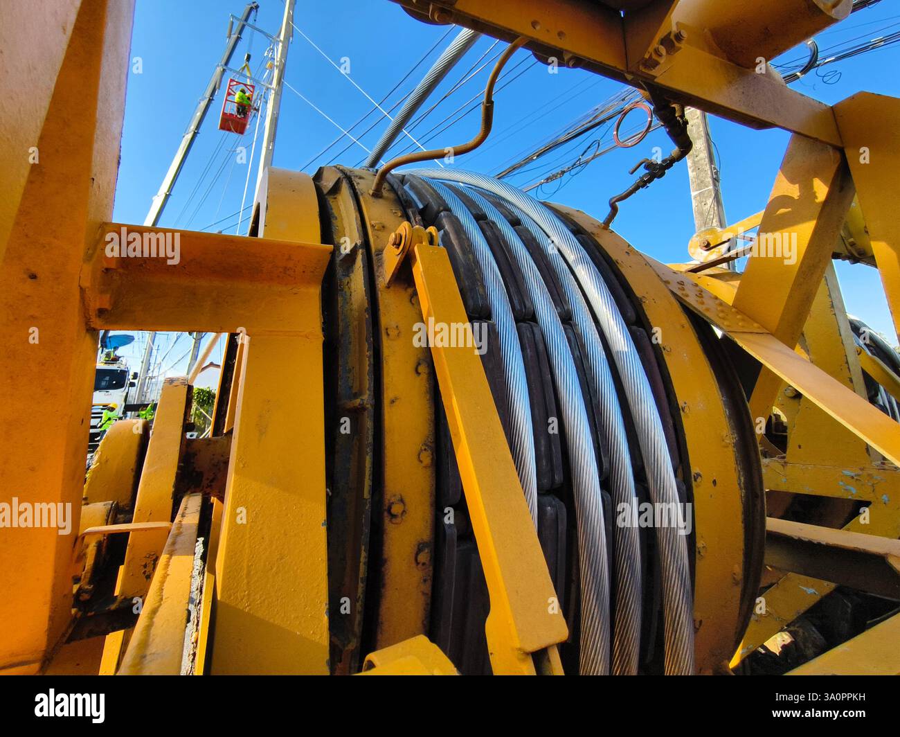 Installation of high-voltage electric wires on new poles along the road ...