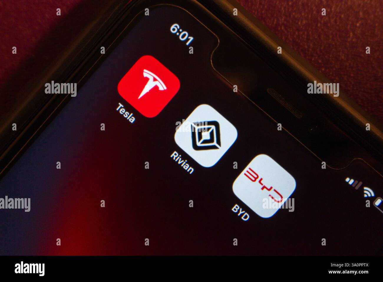 Tesla, Rivian, and BYD icons are displayed on an iPhone. Leading EV ...