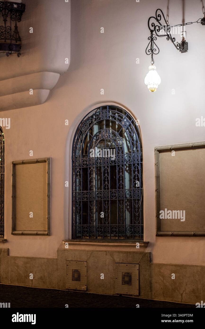 Decorative arched window with blue wrought iron grill on an old ...