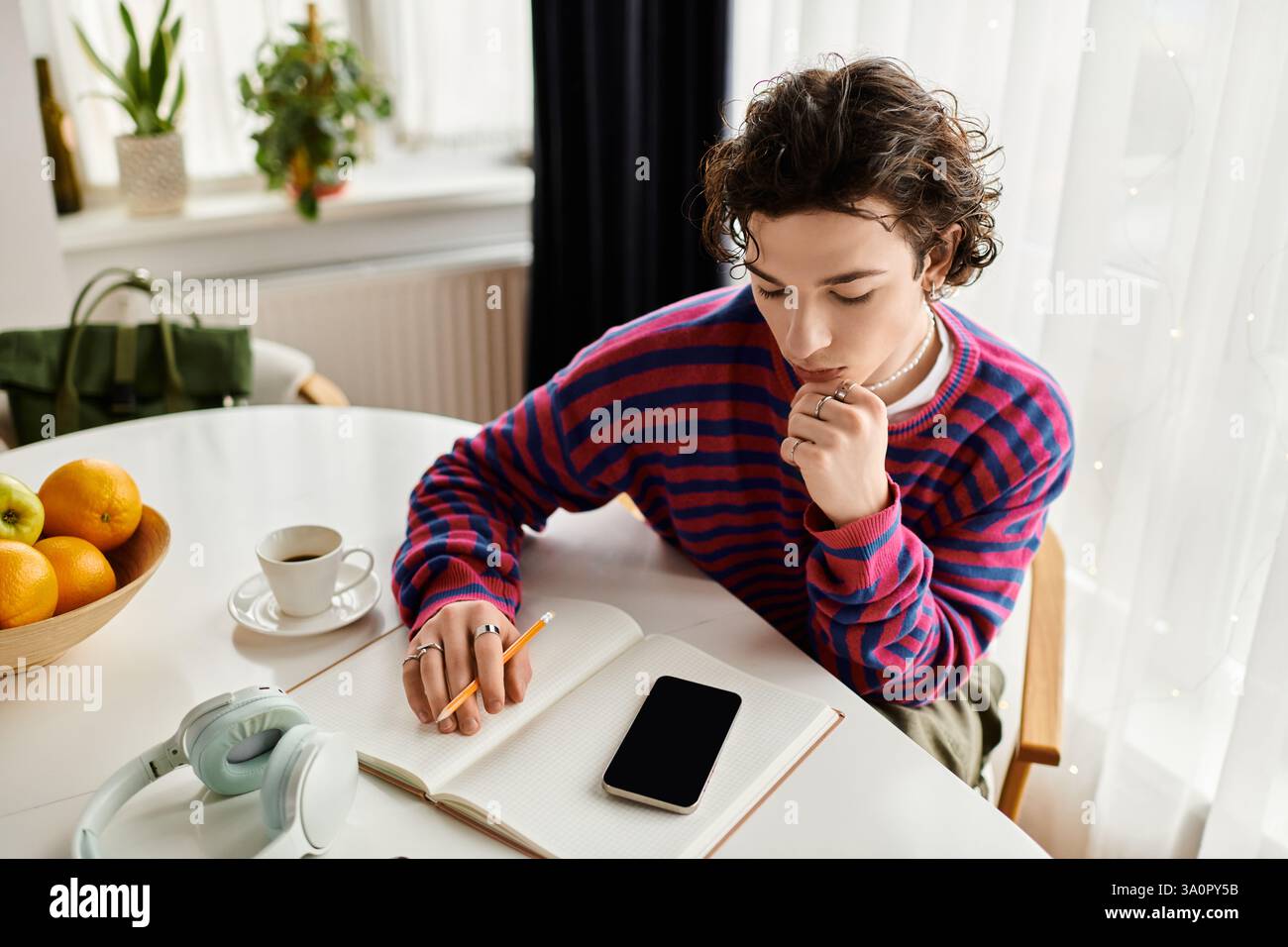 A young non-binary individual studies thoughtfully in their warm ...